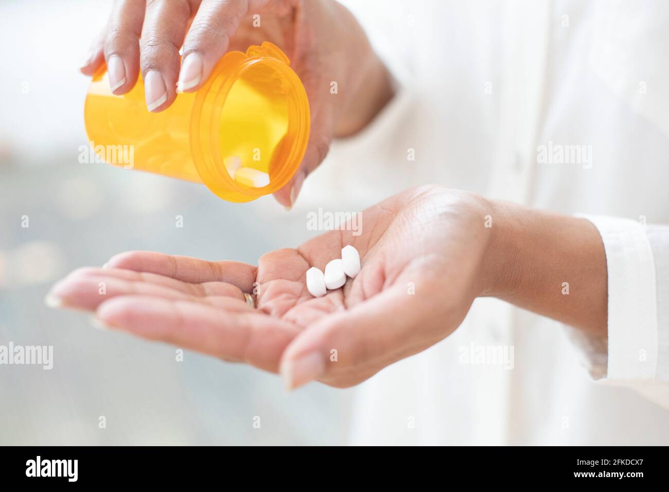 Pouring pills into hand Stock Photo - Alamy