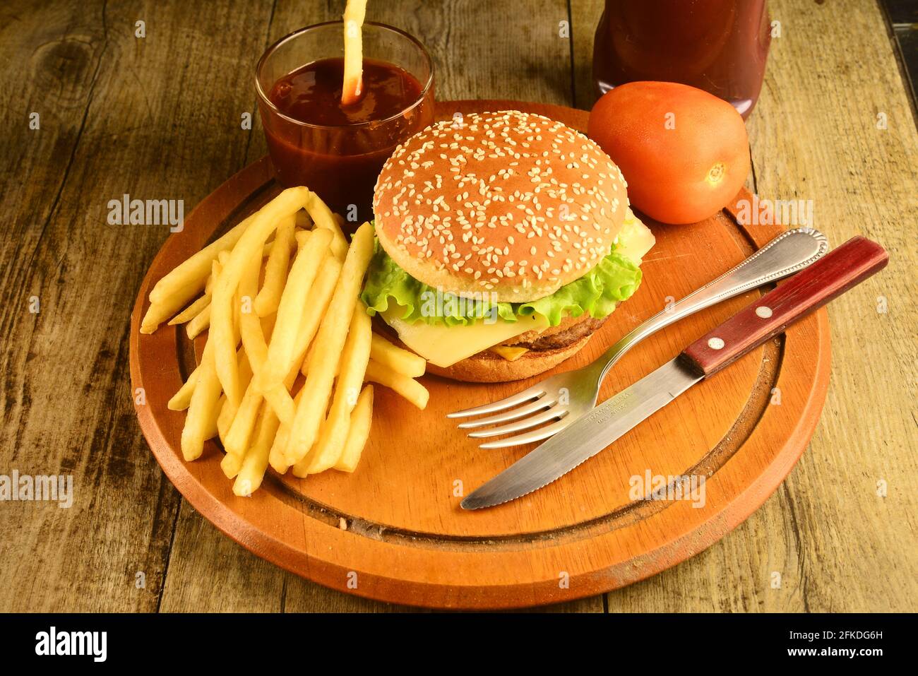 Cheeseburger and chips on a wooden plate Stock Photo - Alamy