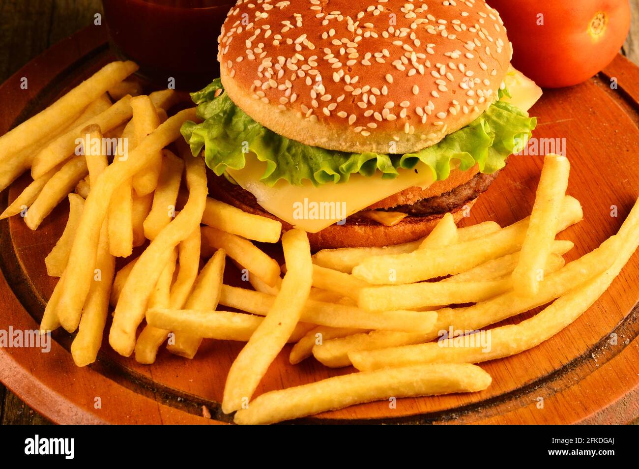 Cheeseburger and chips on a wooden plate Stock Photo - Alamy