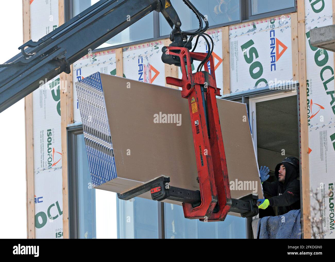 construction worker receives plasterboard load Stock Photo - Alamy