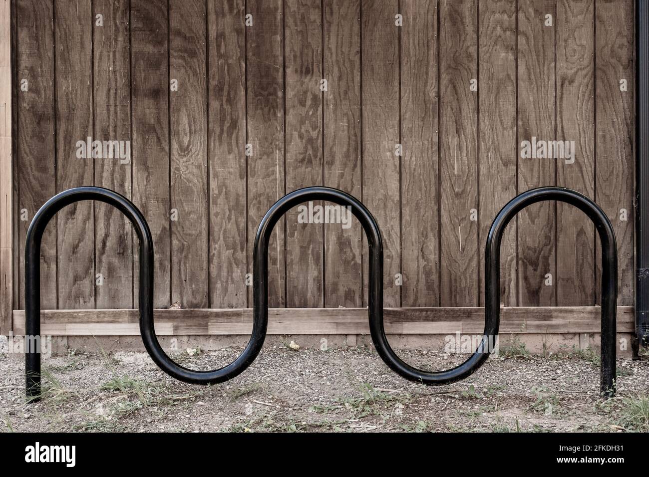 Curved bike rack in front of wooden wall Stock Photo - Alamy