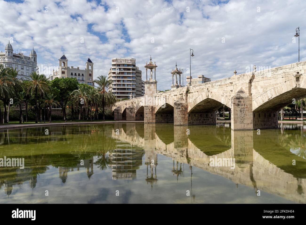 Reflections of an ancient stone bridge across old river bed. Puente del ...