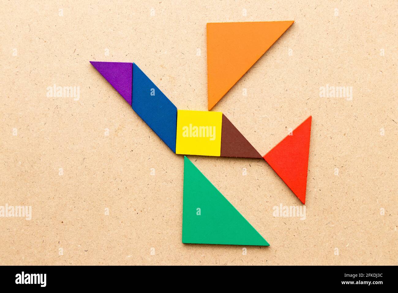 Color tangram puzzle in flying bird shape on wood background Stock ...