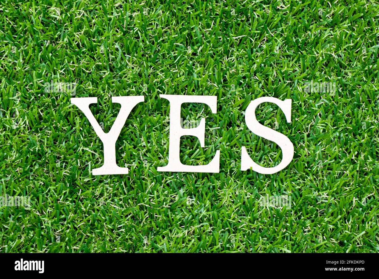 Wood letter in word yes on green grass background Stock Photo - Alamy