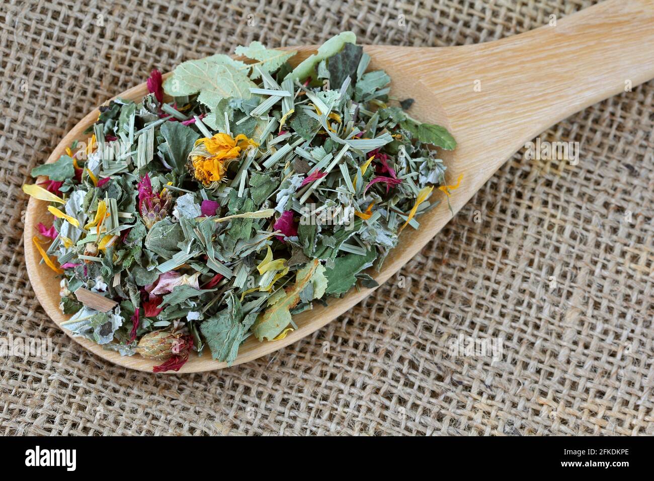 A spoon of dried Herbal tea on a hemp fabric background Stock Photo - Alamy