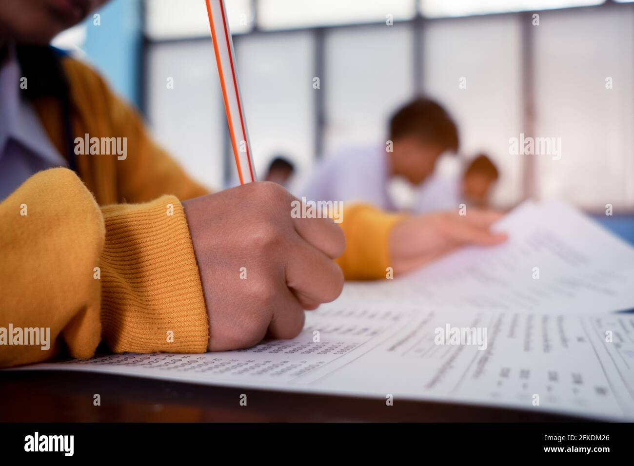 Students writing and reading exam answer sheets exercises in classroom ...