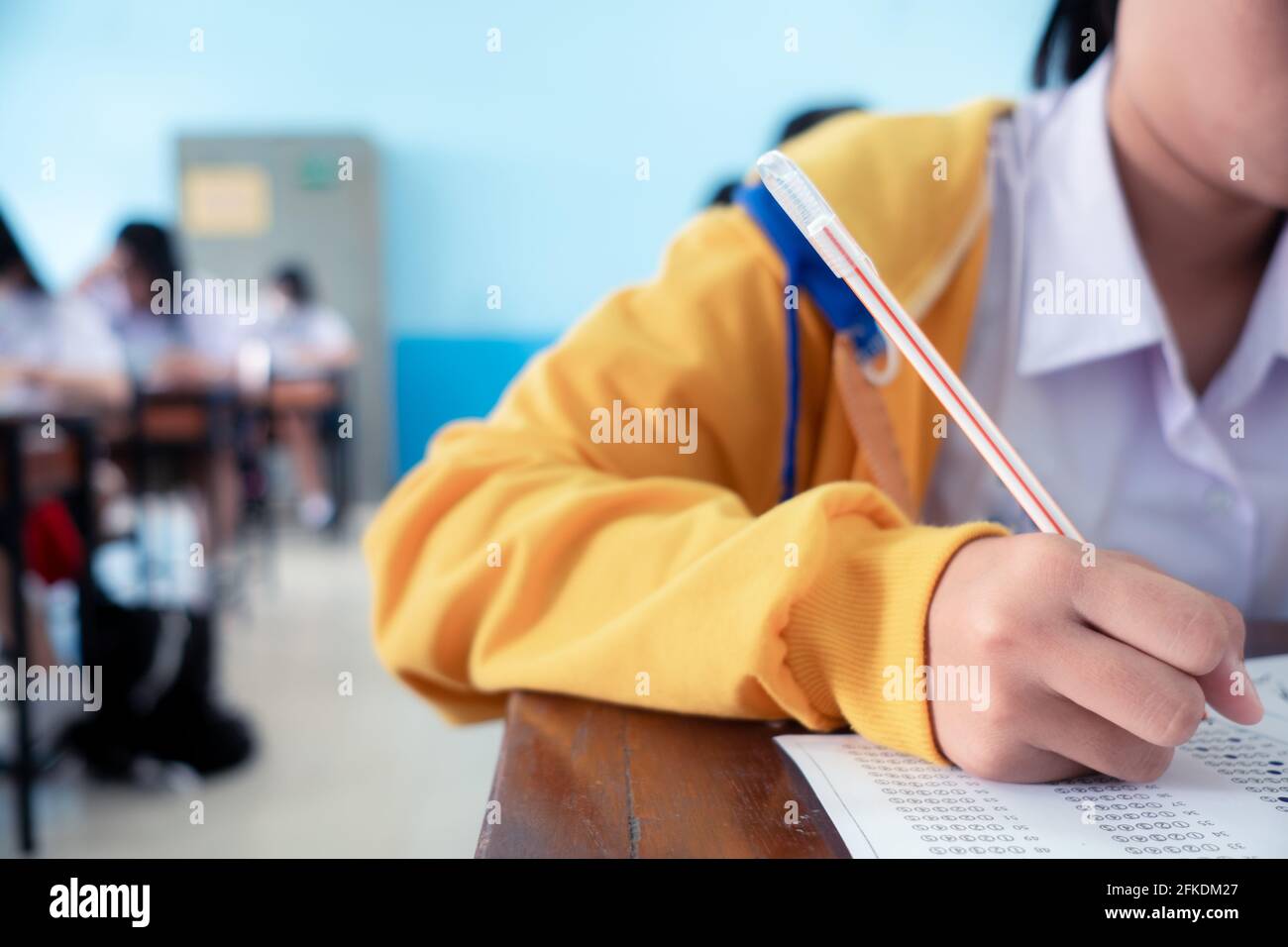 Students writing and reading exam answer sheets exercises in classroom ...