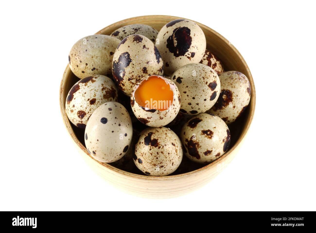 A Wooden bowl full of fresh Quail Eggs, one is opened to show yolk ...