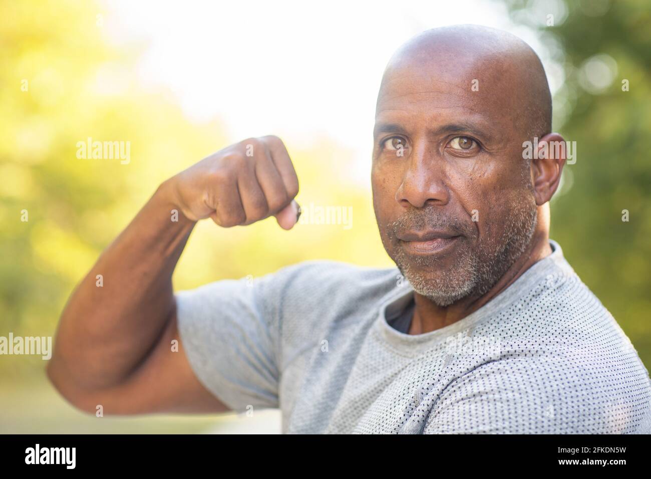 Mature African American flexing his bicep muscle Stock Photo - Alamy