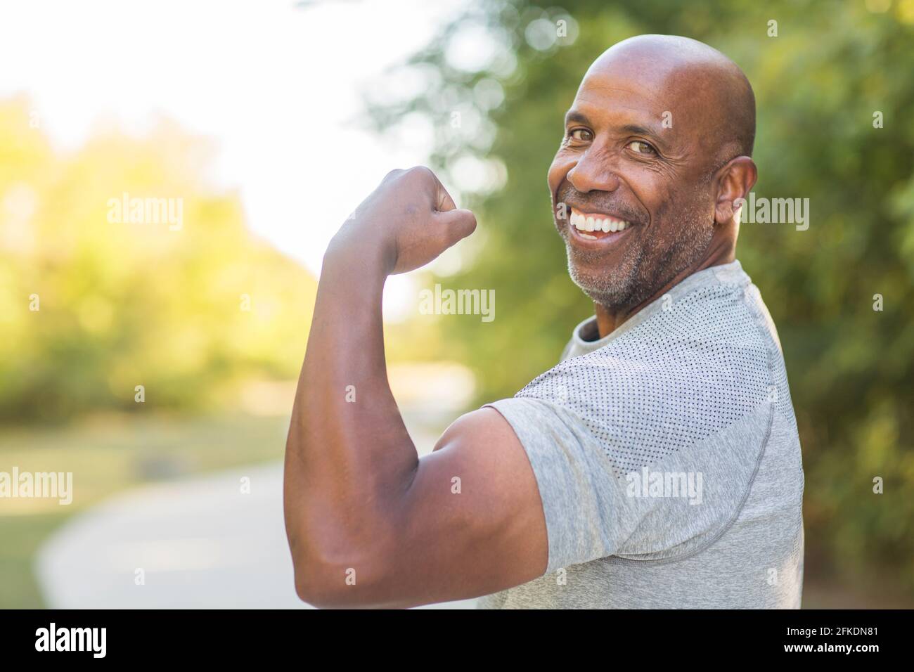 Mature African American flexing his bicep muscle Stock Photo - Alamy