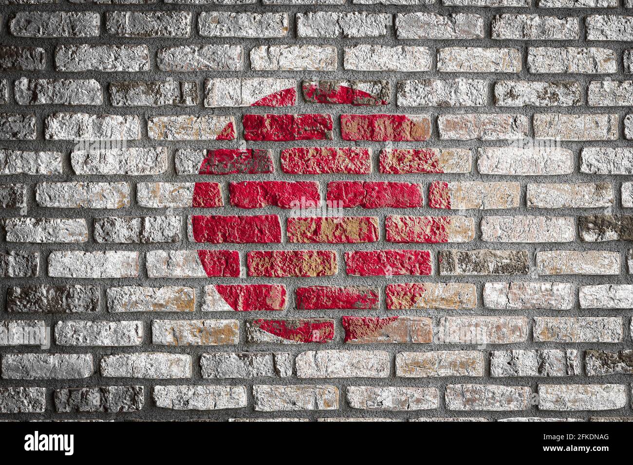 National flag of Japan depicting in paint colors on an old brick wall ...
