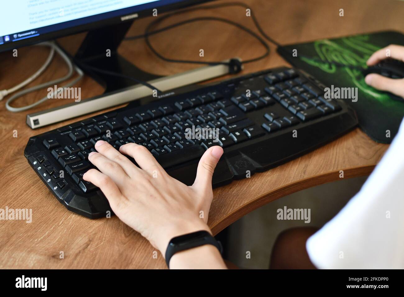 Teenager hands playing computer game with mouse and keyboard. Student ...