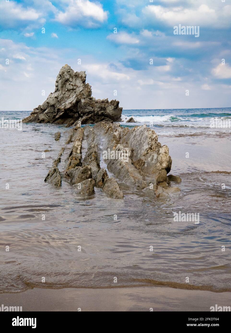 Rocks protruding from the sea against the beautiful sky Stock Photo - Alamy