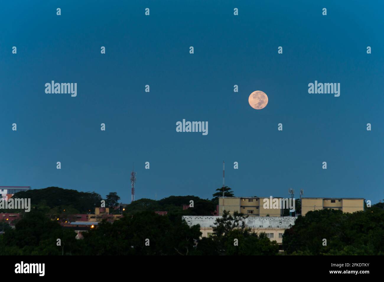 Natural view of the moon setting over a village in the East of ...