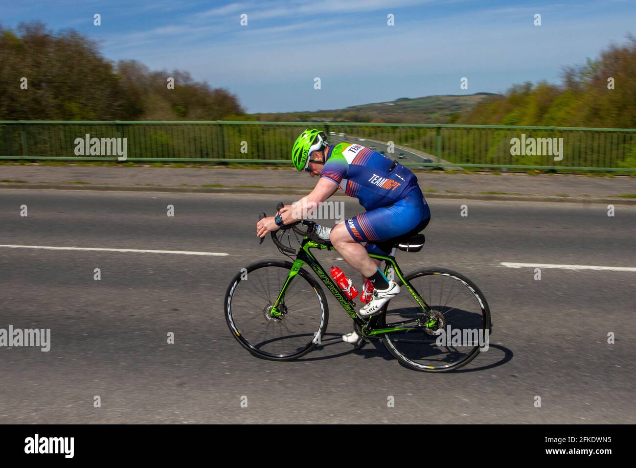 Male cyclist riding Cannondale sports road bike, blurred, low shutter ...