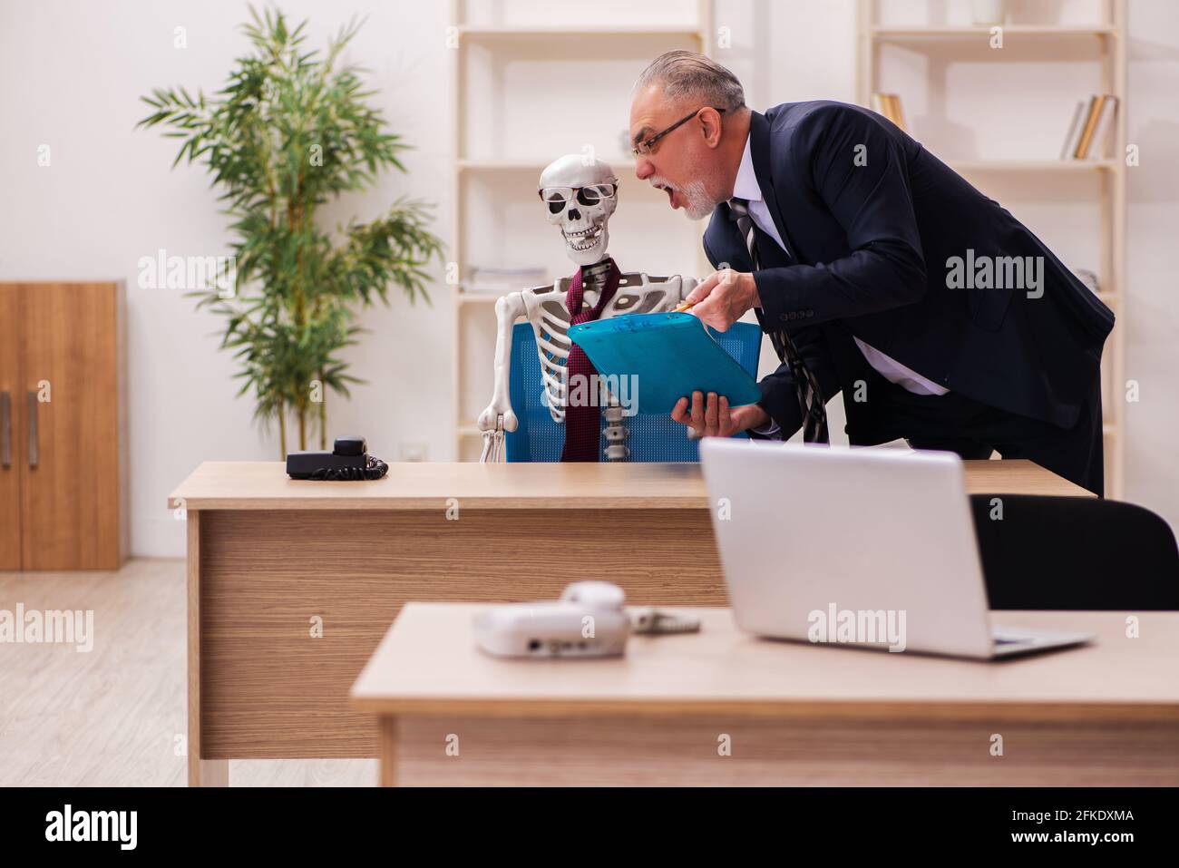 Dead employee working in the office in funny concept Stock Photo - Alamy
