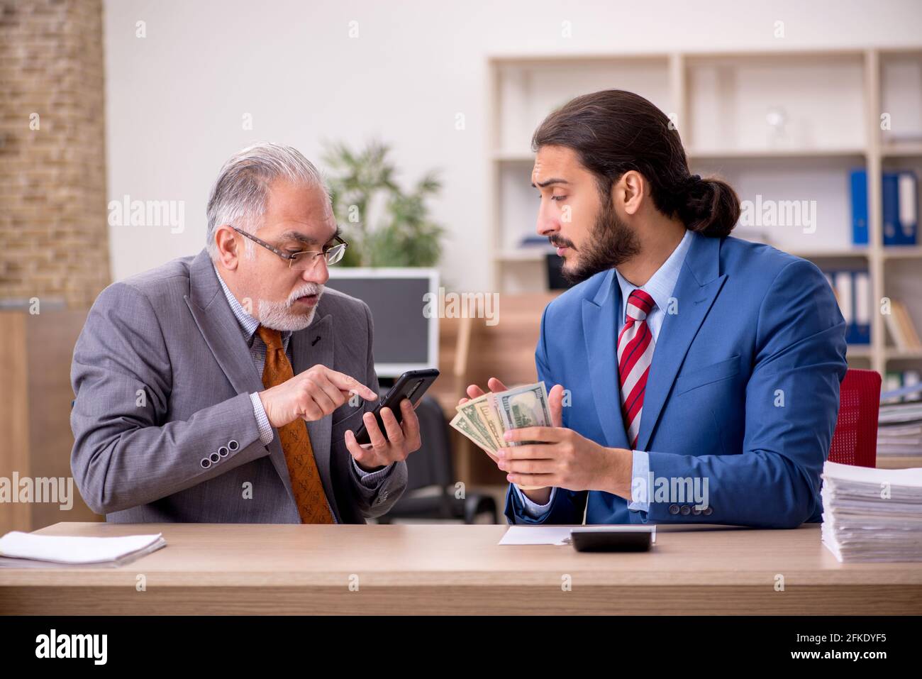 Two employees in remuneration concept Stock Photo - Alamy