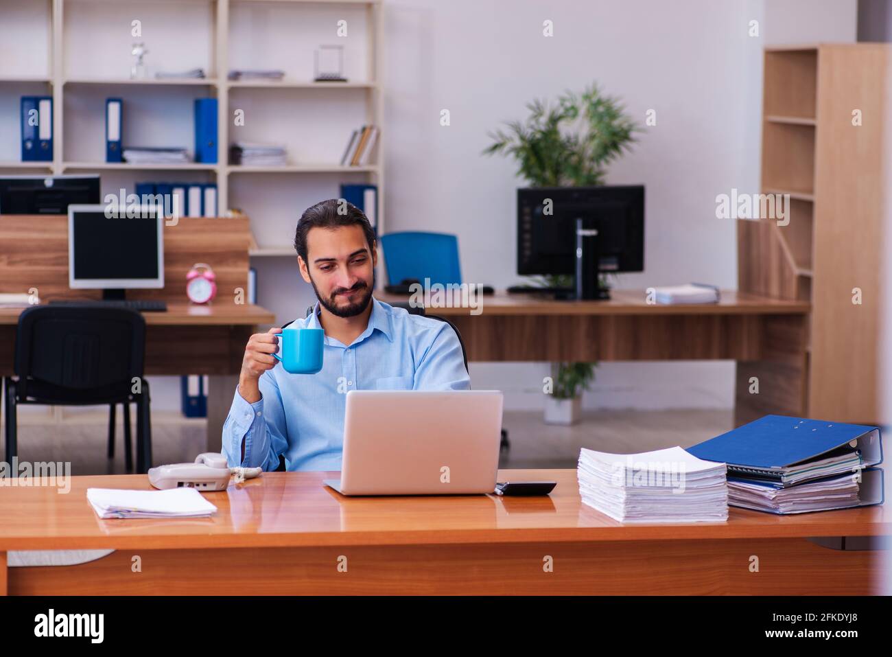 Young employee drinking tea during break Stock Photo - Alamy