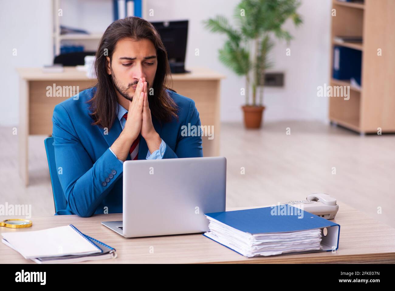 Young employee working at workplace Stock Photo - Alamy