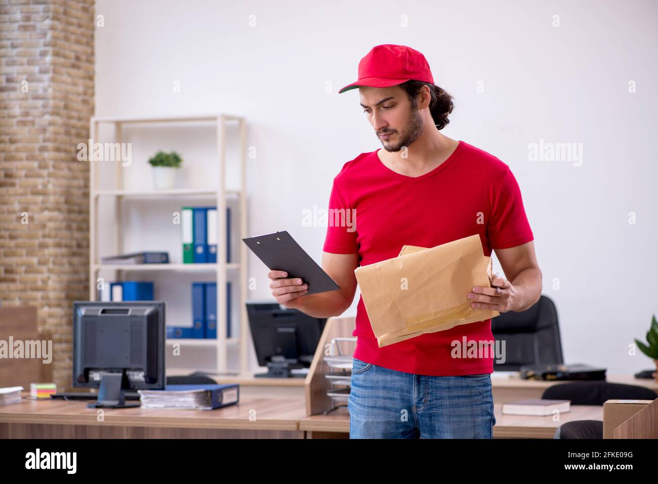 Young courier delivering post to the office Stock Photo - Alamy