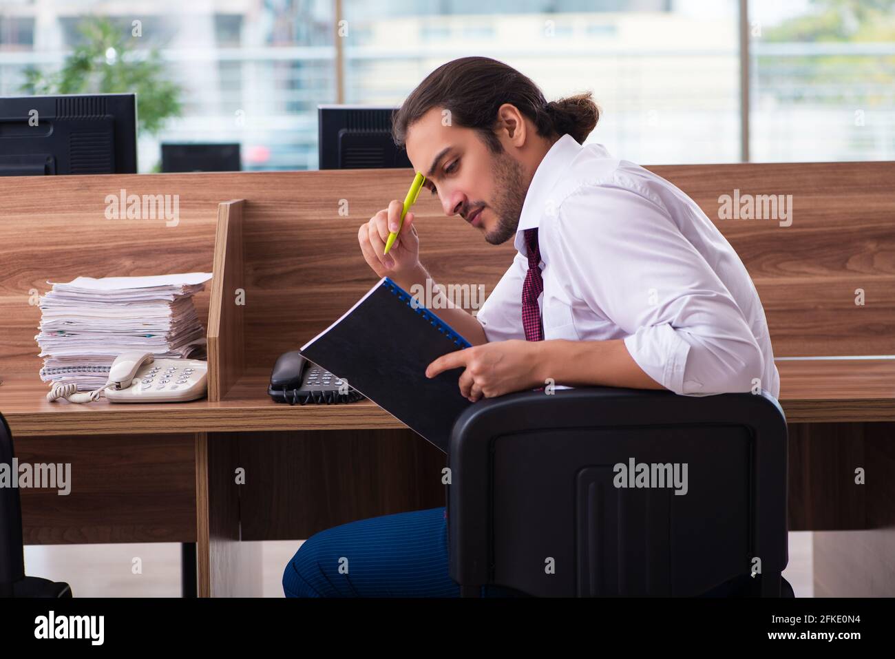 Young employee and too many work in the office Stock Photo - Alamy