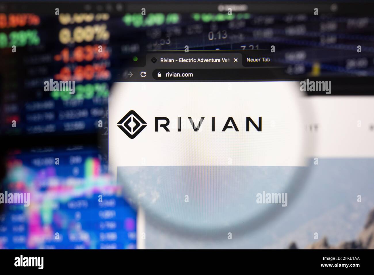 Rivian company logo on a website with blurry stock market developments ...