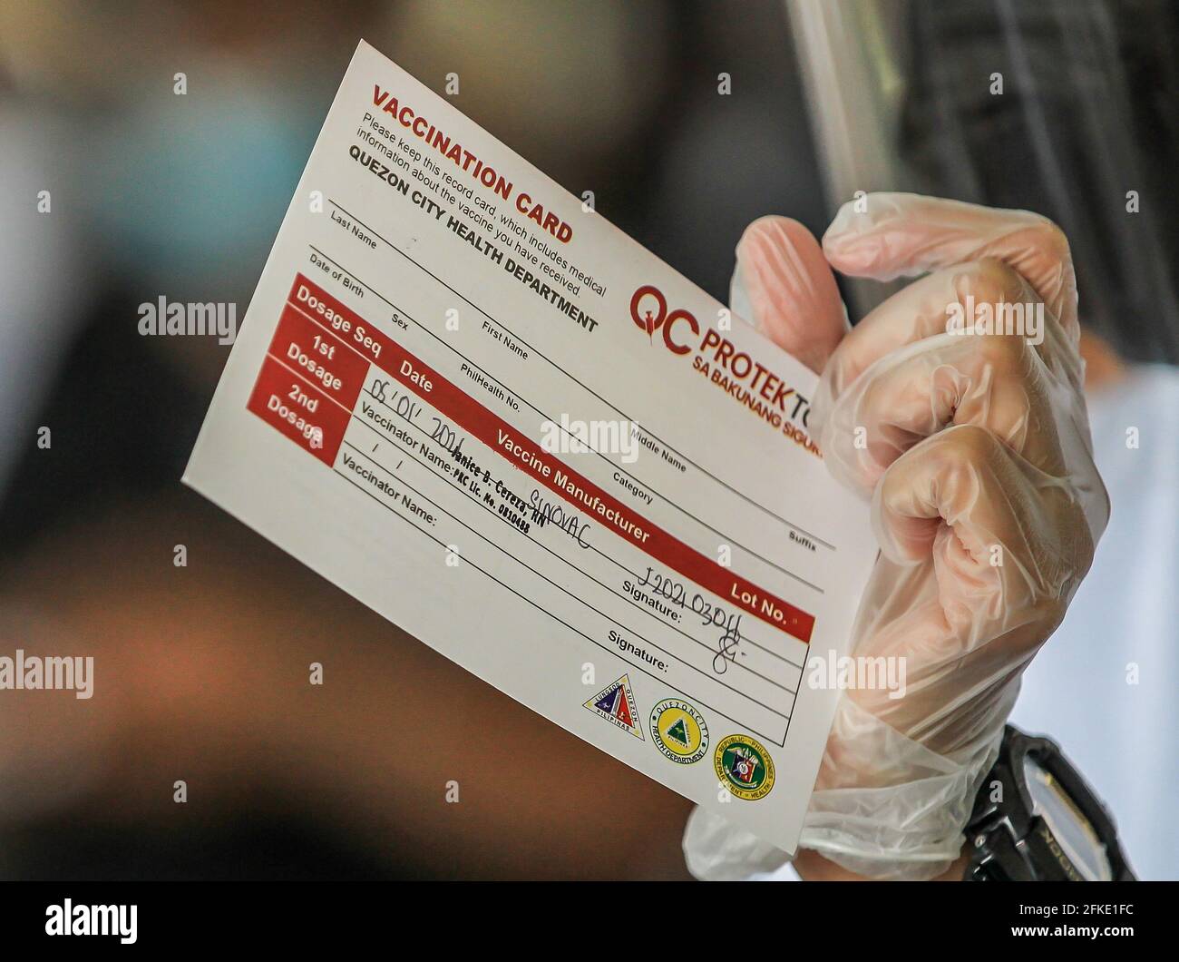 Manila. 1st May, 2021. A health worker shows a vaccination card before ...