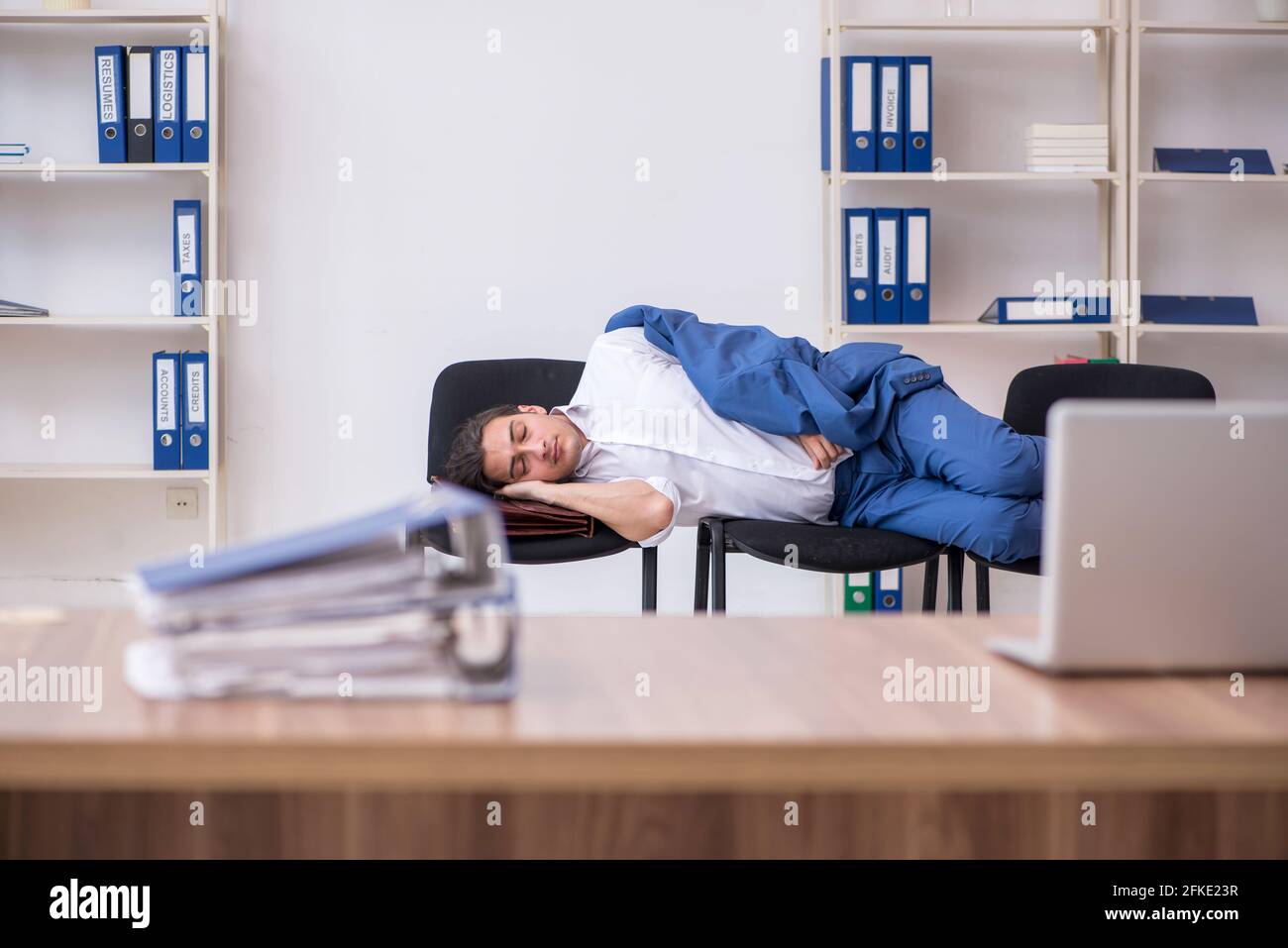 Young employee sleeping in the office on chairs Stock Photo - Alamy