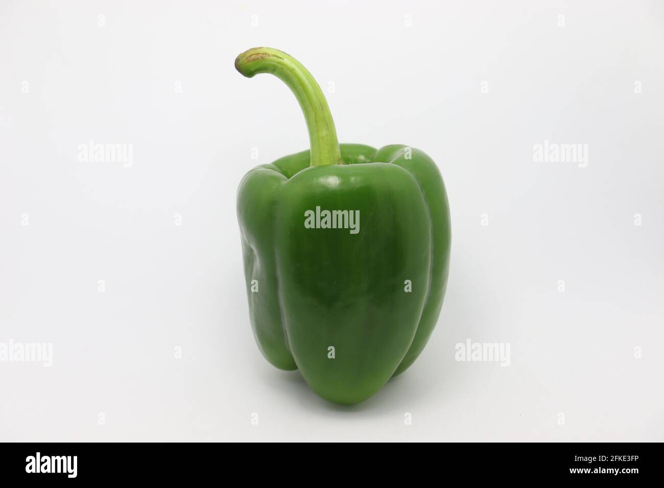 green colored capsicum closeup on white background Stock Photo - Alamy