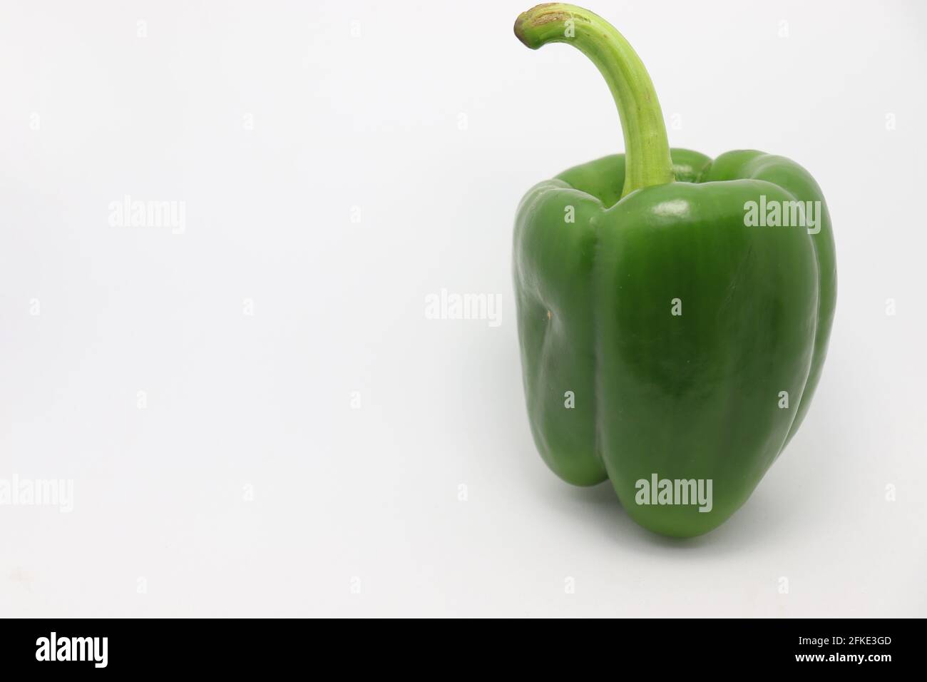 green colored capsicum closeup on white background Stock Photo - Alamy
