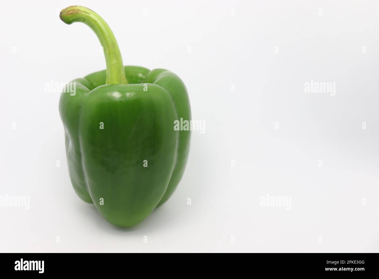 green colored capsicum closeup on white background Stock Photo - Alamy