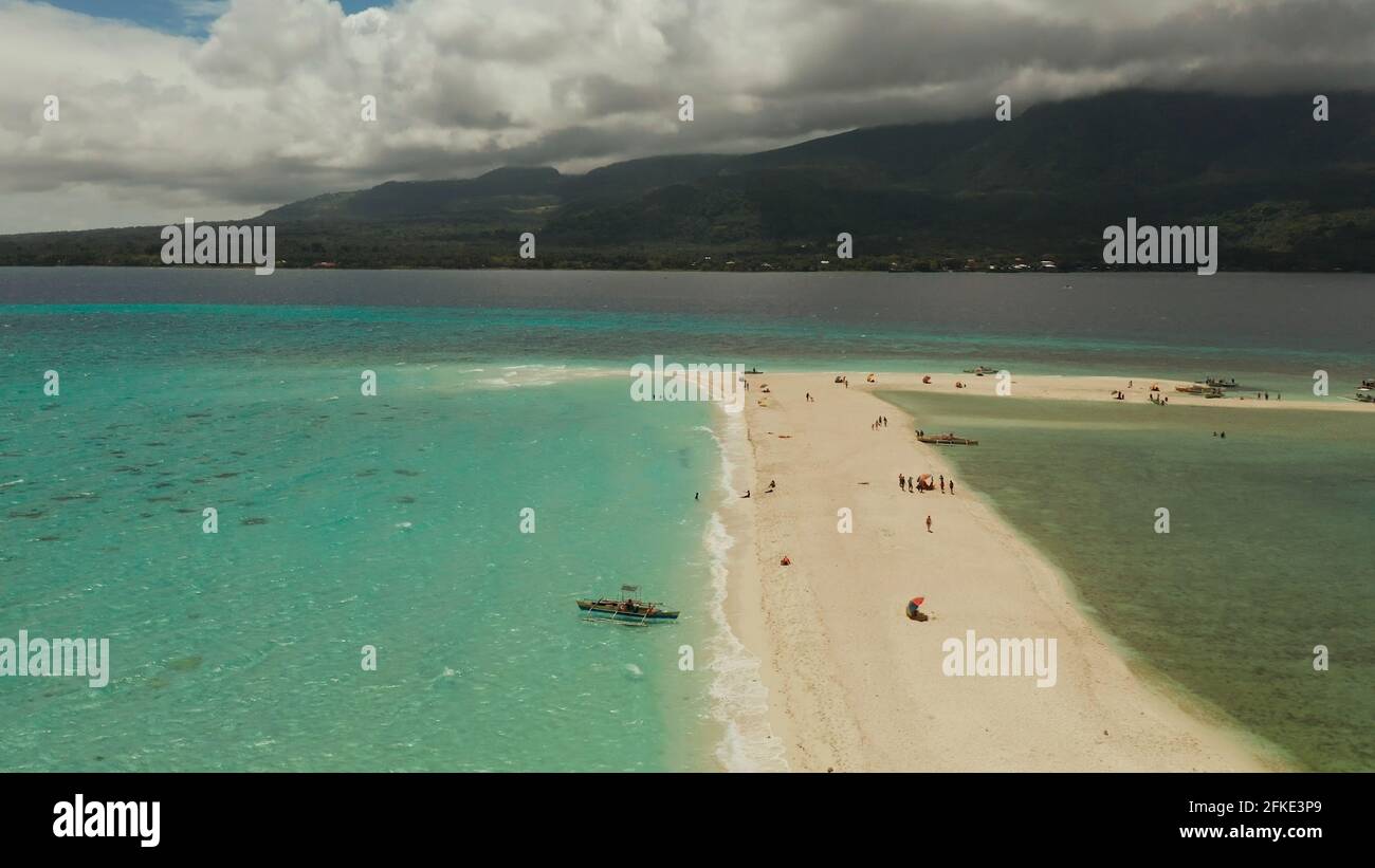 Tropical white island and sandy beach with tourists surrounded by coral ...