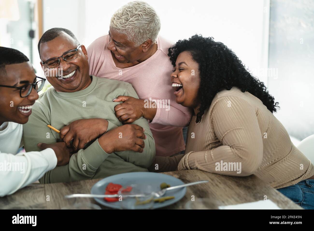 Happy African family having fun after a lunch together at home - Food ...