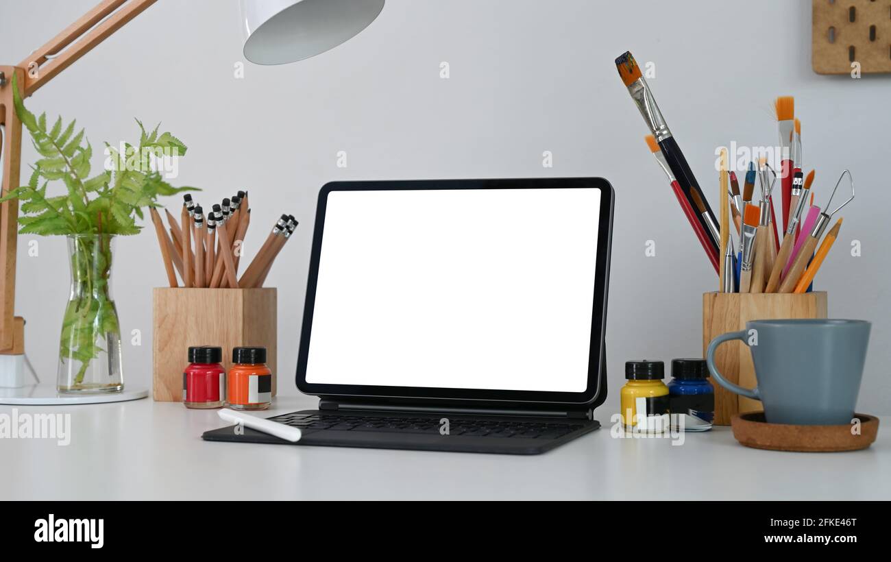 Mock up computer tablet, coffee cup, stylus pen and painting tools at ...