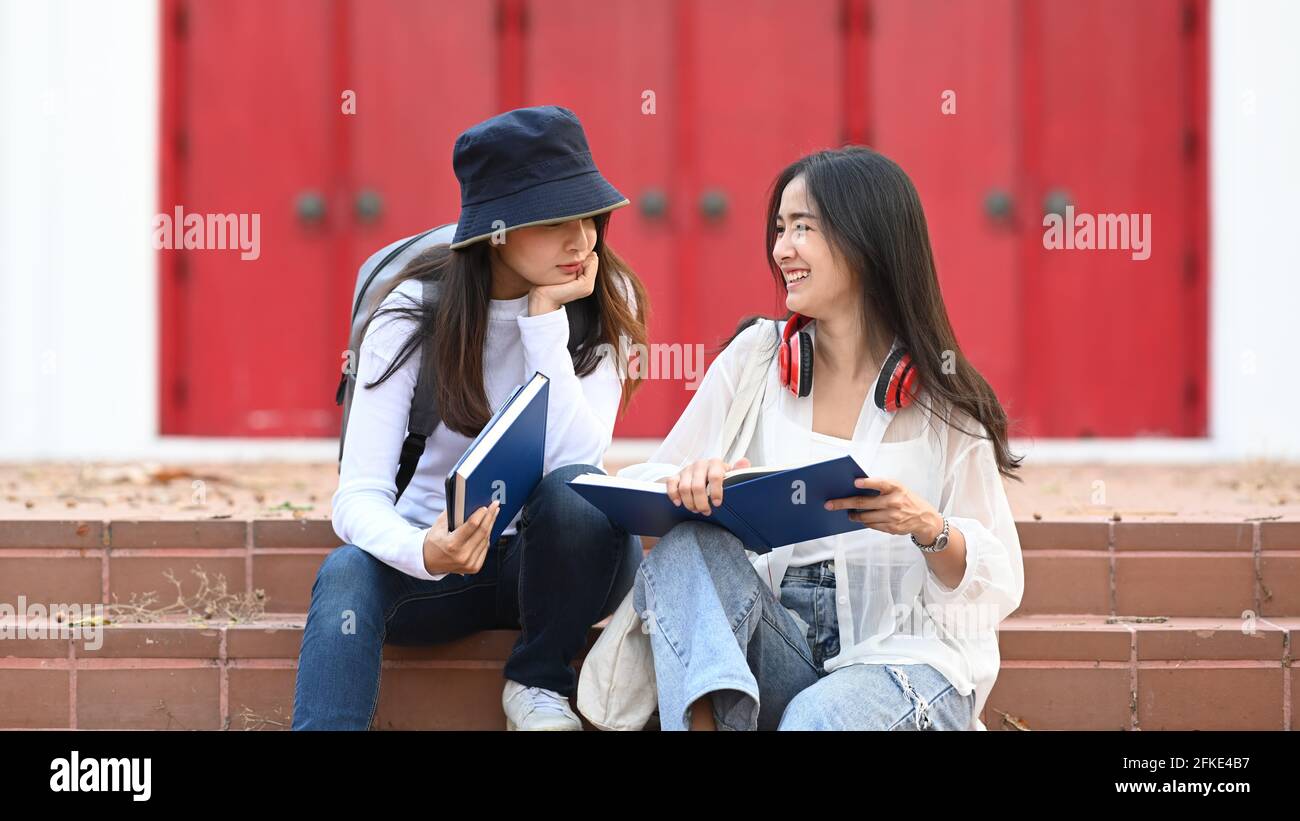 Two college student reading interesting book and prepare for exam while ...