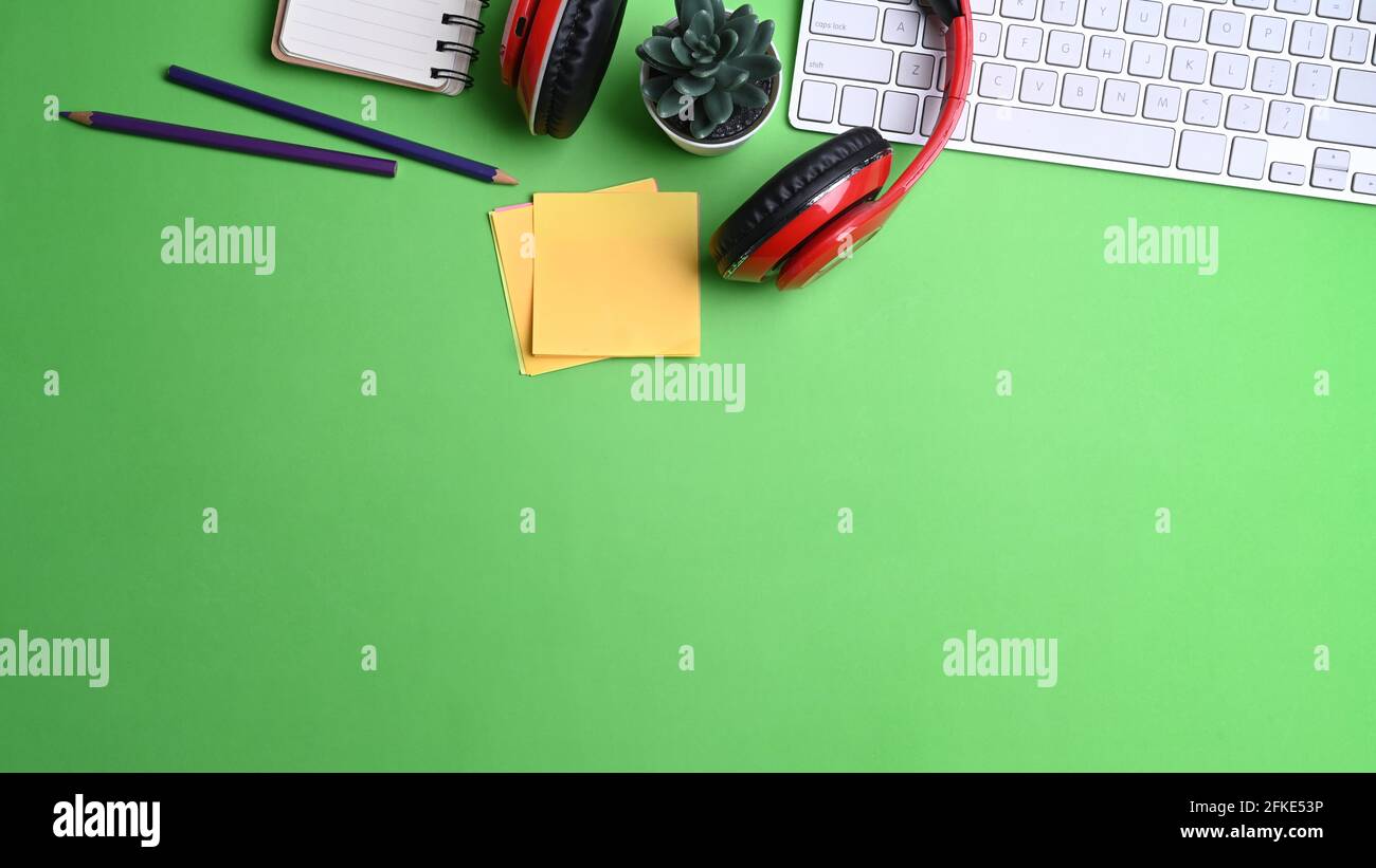 Top view of creative workplace with headphone, sticky notes, keyboard ...