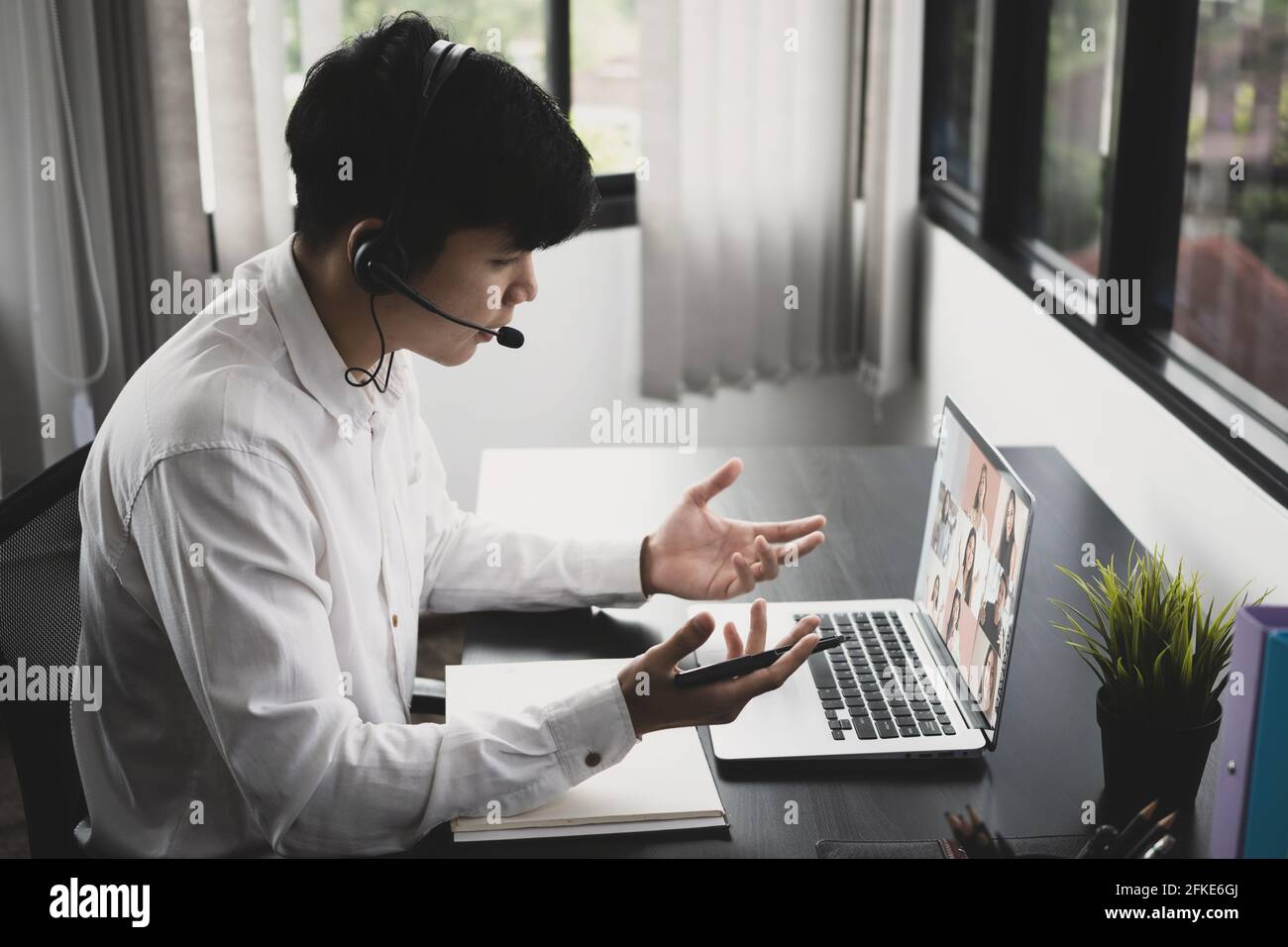 Side view of businessman using laptop computer and talking to his ...