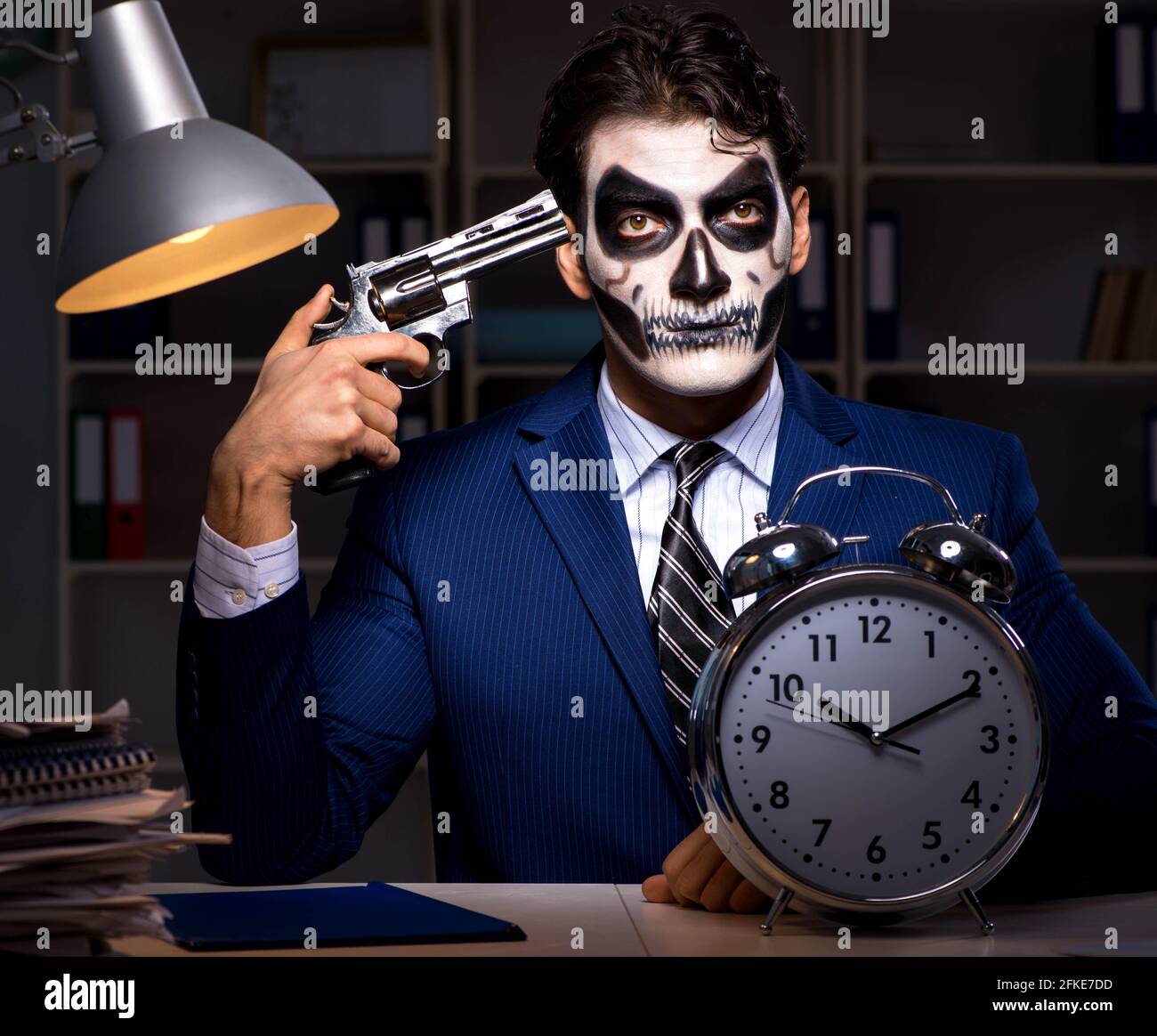 The businessman with scary face mask working late in office Stock Photo ...