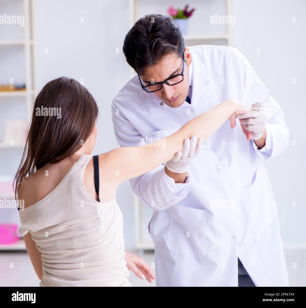 The doctor examining the skin of female patient Stock Photo - Alamy