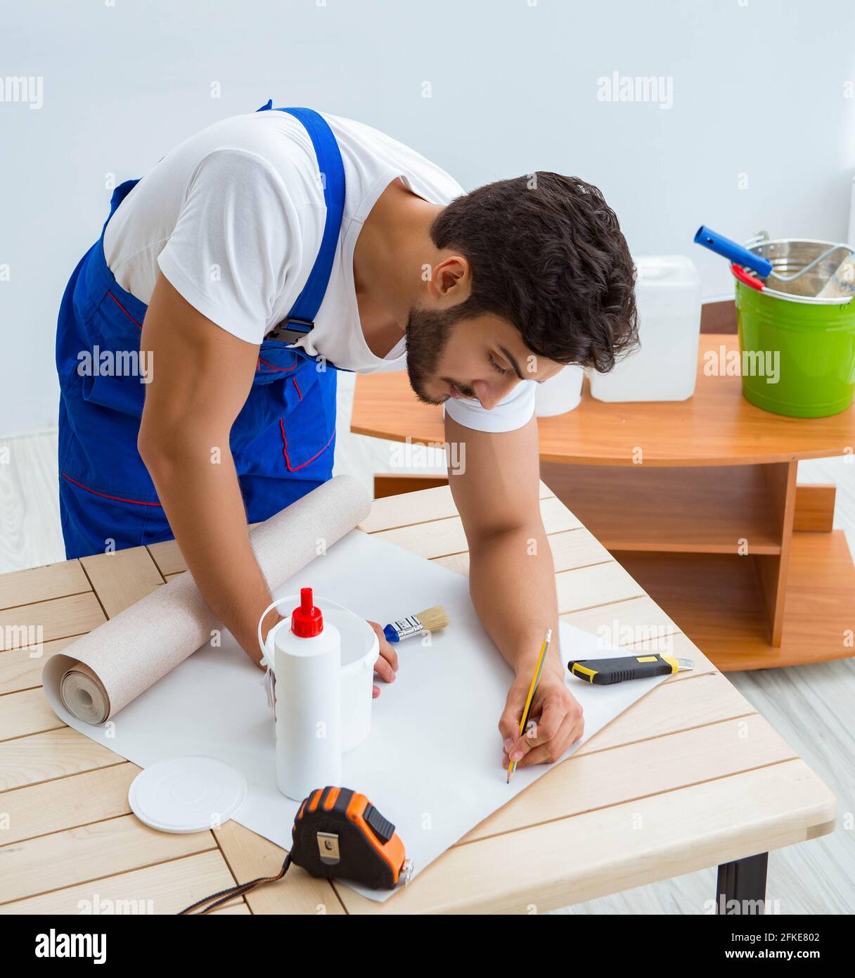 The worker working on wallpaper during refurbishment Stock Photo - Alamy