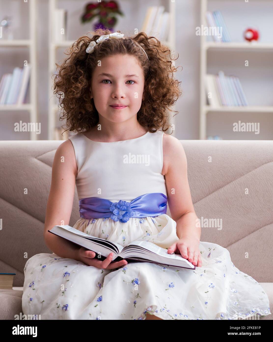 Small girl reading books at home Stock Photo - Alamy