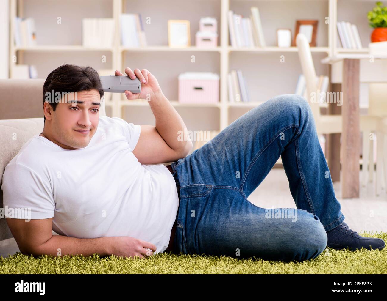 The man watching tv at home on floor Stock Photo - Alamy