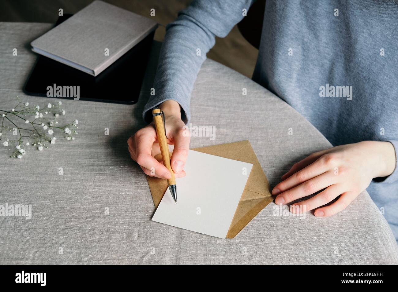 Female hands writing wedding invitation card. Blank paper card ...