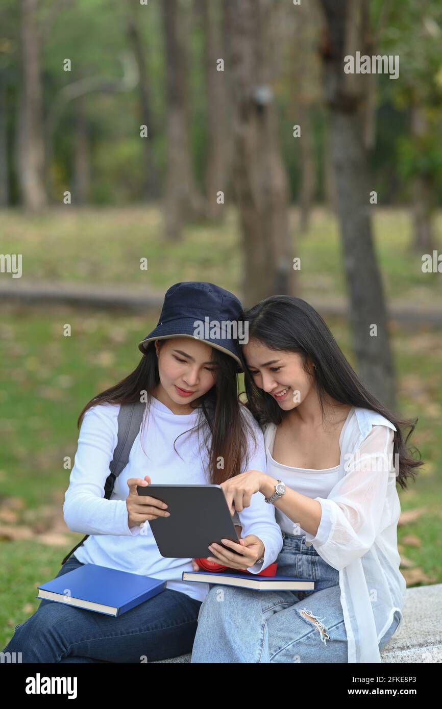 Two college students resting in park and chatting after lecture Stock ...