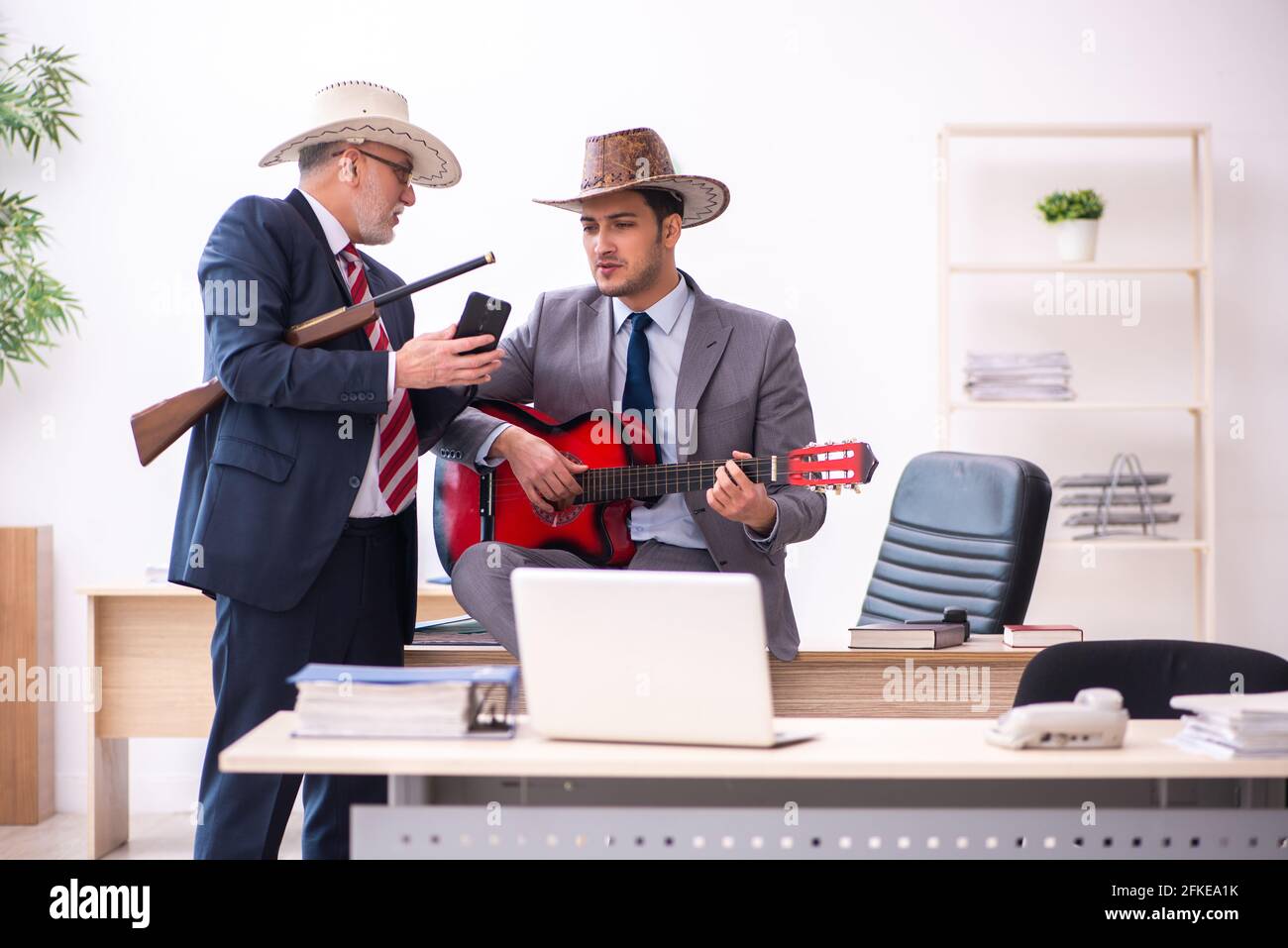 Two male cowboy employees during break in the office Stock Photo - Alamy