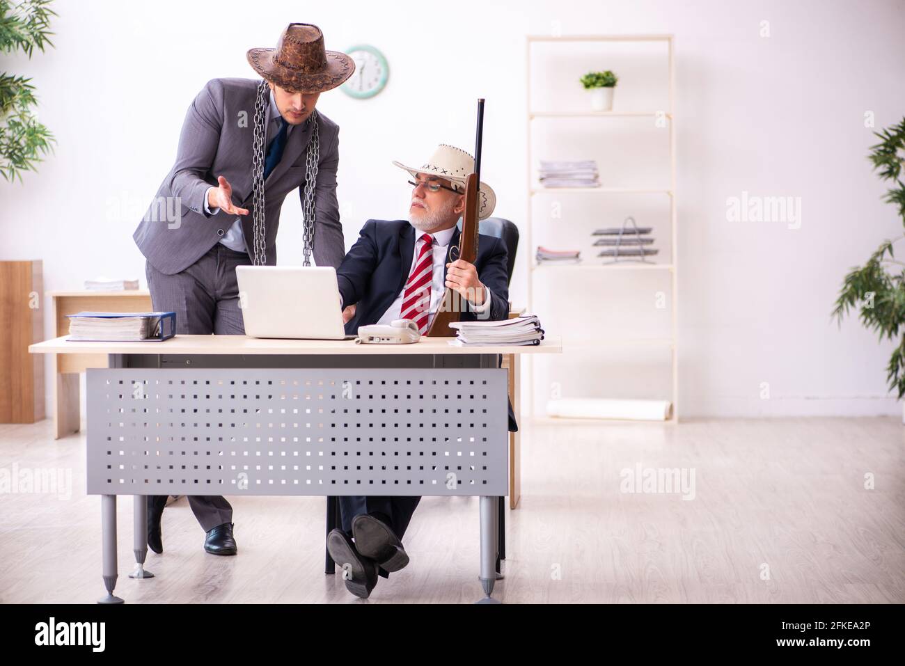 Two cowboy employees in funny concept Stock Photo - Alamy