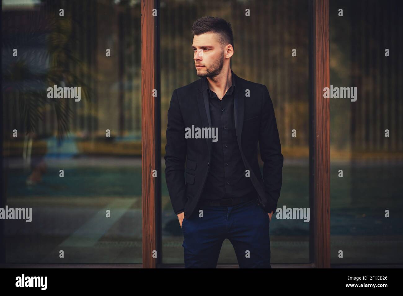 attractive young male model posing outdoors in black jacket and shirt ...