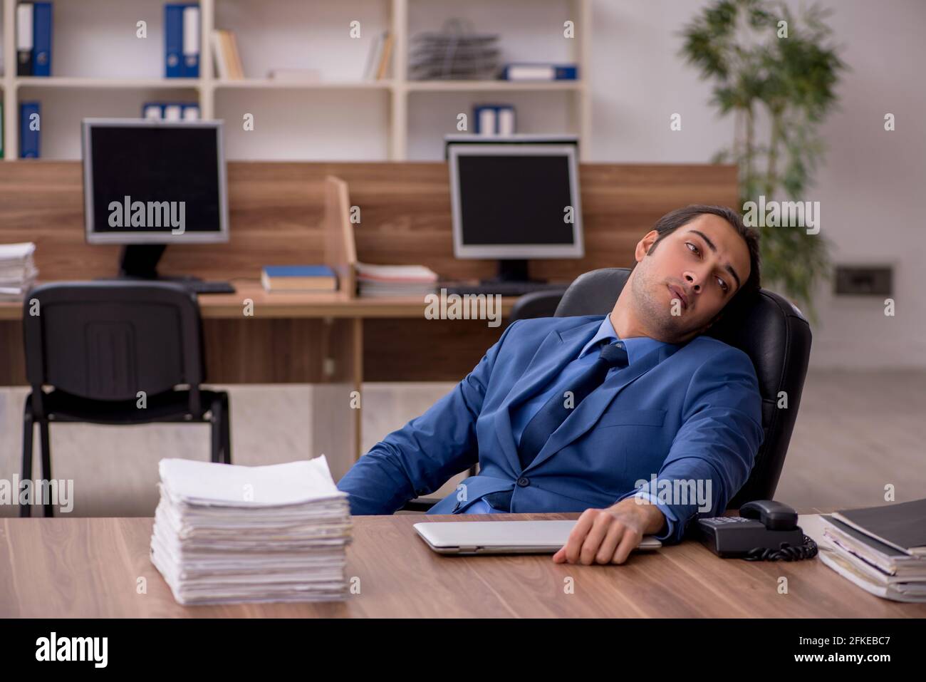 Young businessman employee and a lot of work in the office Stock Photo ...