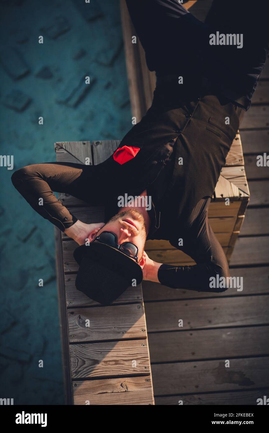 Portrait of a stylish and independent man lying in the shade. rest ...