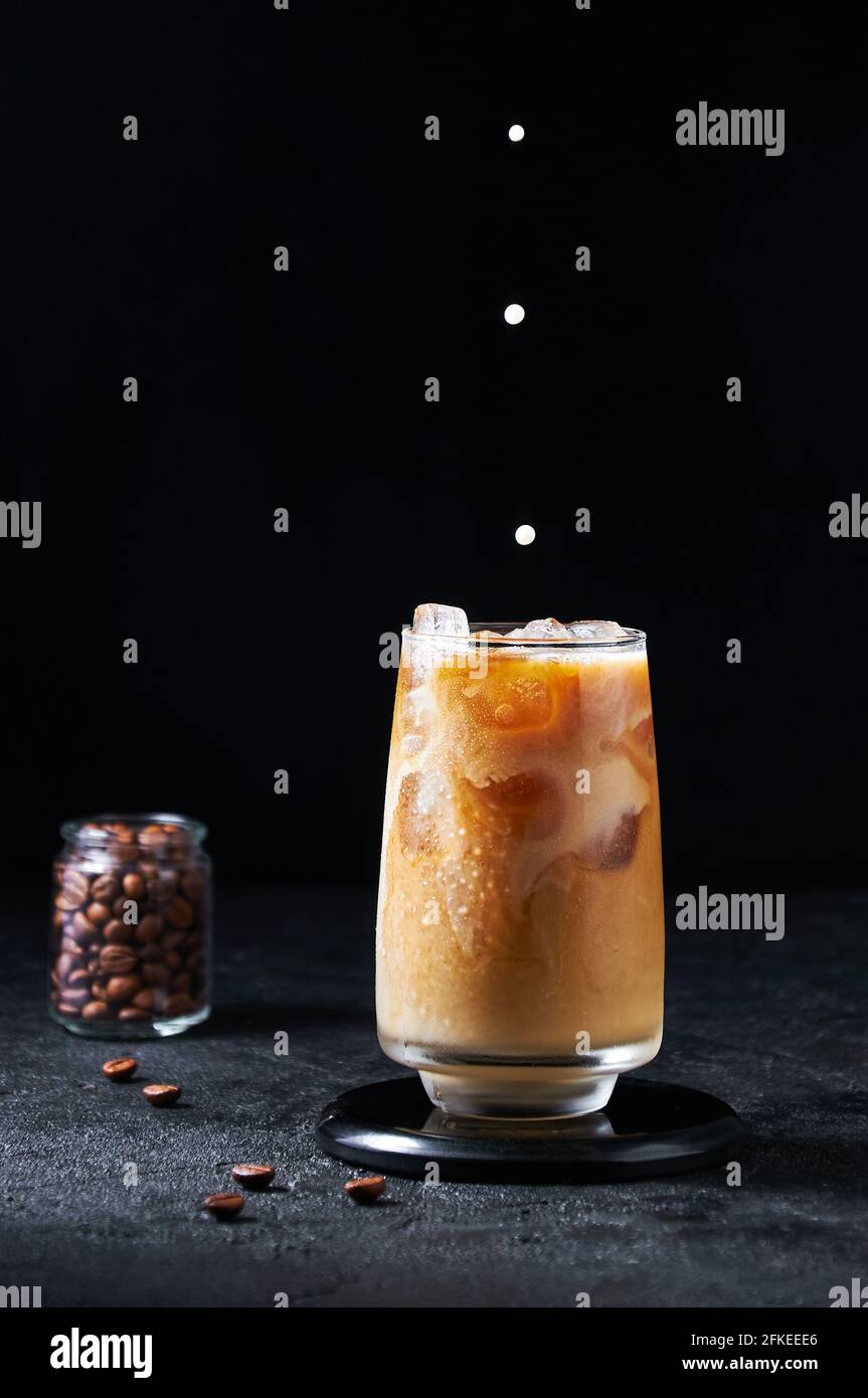 Milk Being Poured into Iced Coffee in Tall Glass on Dark Background. Concept Refreshing Summer ...